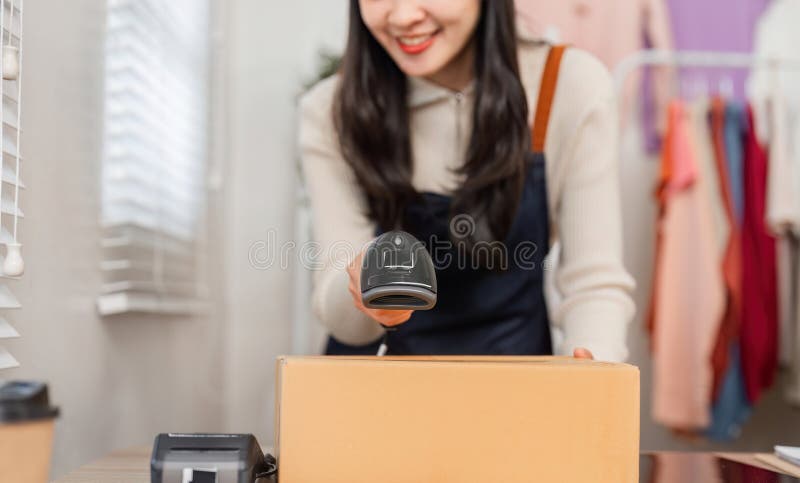 Diverse Young Woman Scanning a Cardboard Box with a Barcode Scanner in ...