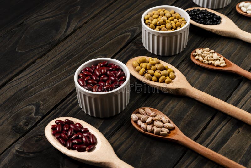 Diversity of Beans Inside Wooden Spoons. Black Wood Background Stock ...