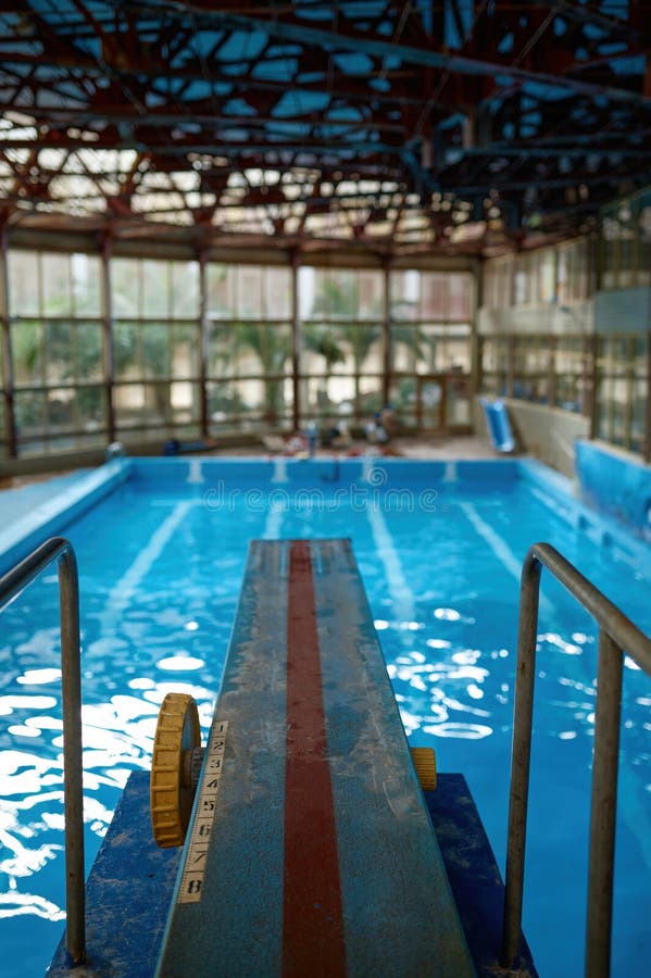 Diving Board at Empty Swimming Pool with Reflections of Light in Water ...