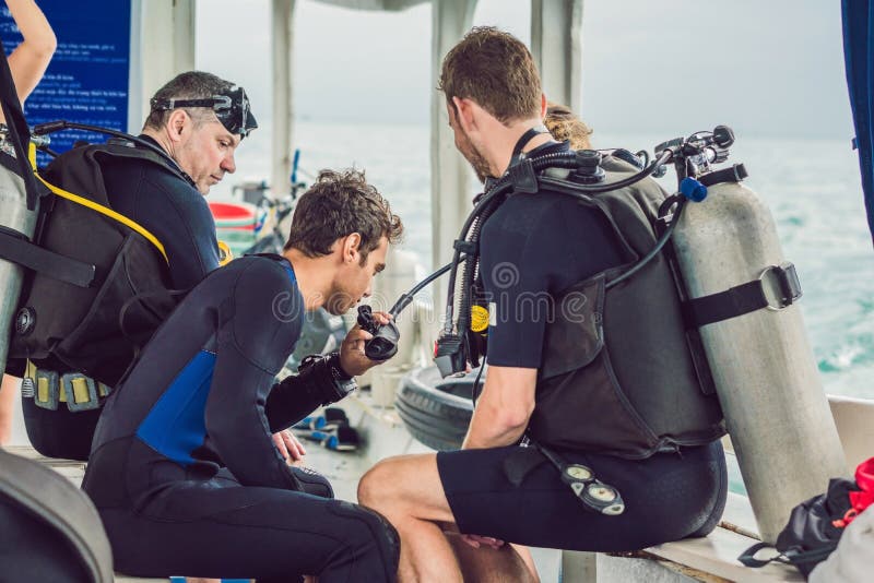 Diving Instructor Helps a Beginner Diver Prepare for Diving Stock Photo ...
