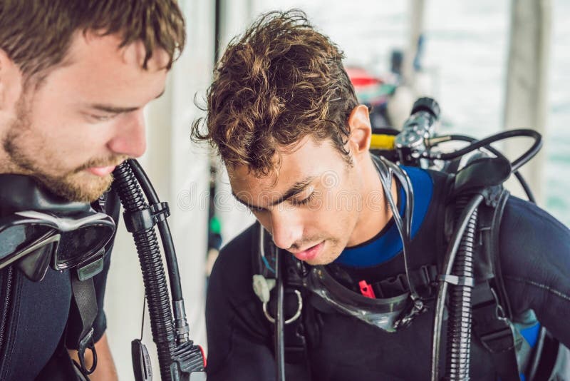 Diving Instructor Helps a Beginner Diver Prepare for Diving Stock Image ...
