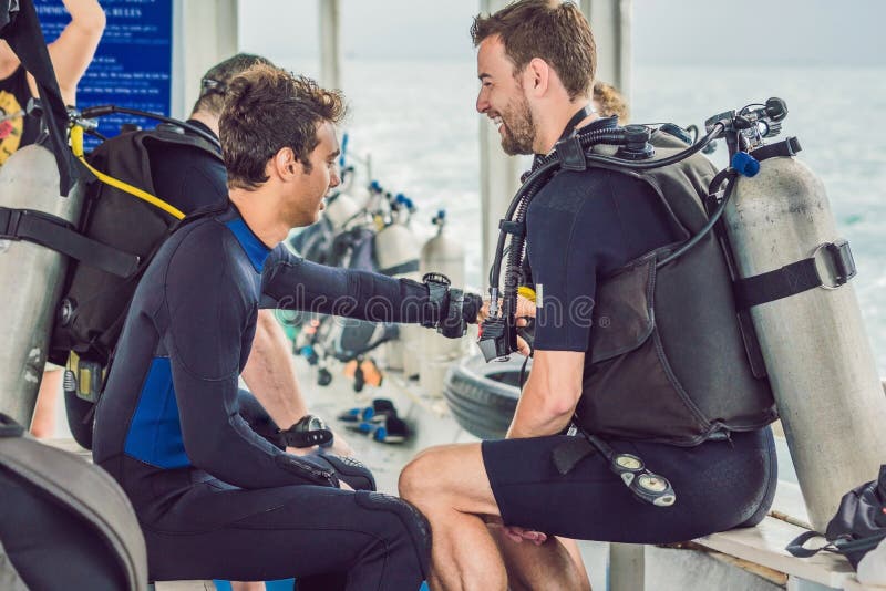 Diving Instructor Helps a Beginner Diver Prepare for Diving Stock Photo ...