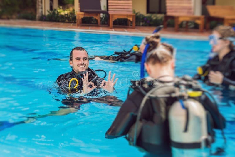 Diving Instructor and Students. Instructor Teaches Students To Dive ...