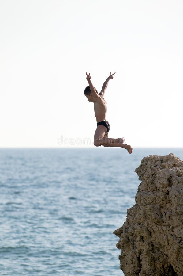 Boy jumping to the sea stock photo. Image of rock, resort - 7472728