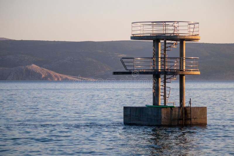 Diving Tower in the Middle of a Seascape with Mountains in the ...