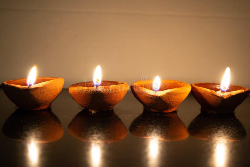 Diwali Diyas Lined Up in a Row on a Reflective Surface Stock Photo ...