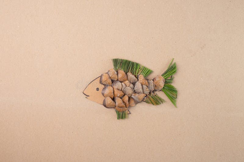 DIY Fish Craft Using Pinecone Scales, Pine Needles, on a Beige ...