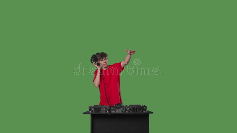 DJ Mixing Music on a Turntable in a Studio on a Green Screen Background ...