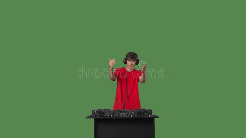 DJ Mixing Music on a Turntable in a Studio on a Green Screen Background ...