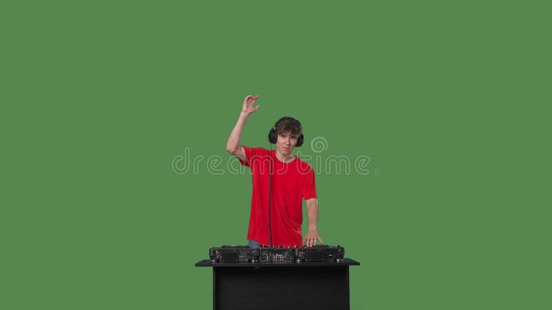 DJ Mixing Music on a Turntable in a Studio on a Green Screen Background ...