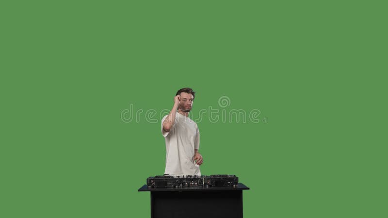 DJ Mixing Music on a Turntable in a Studio on a Green Screen Background ...