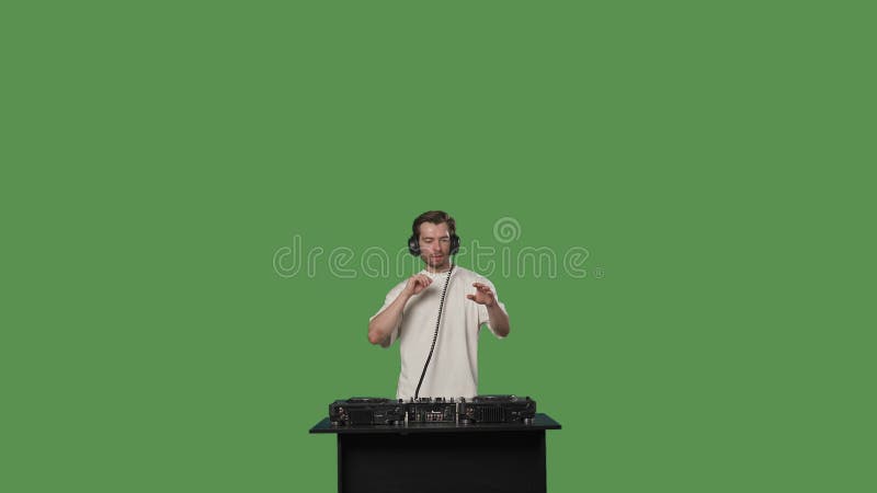 DJ Mixing Music on a Turntable in a Studio on a Green Screen Background ...