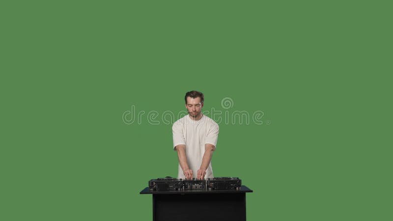 DJ Mixing Music on a Turntable in a Studio on a Green Screen Background ...