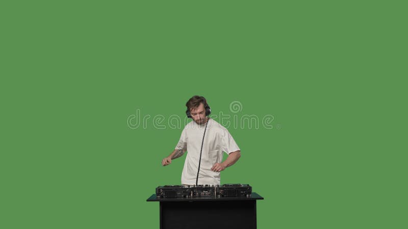 DJ Mixing Music on a Turntable in a Studio on a Green Screen Background ...