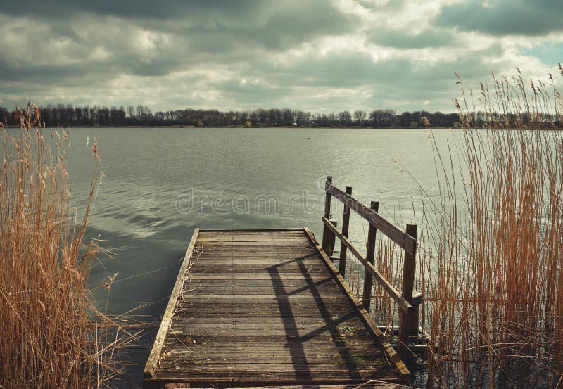Dock on Lake with Tall Grass in the Foreground Stock Photo - Image of ...