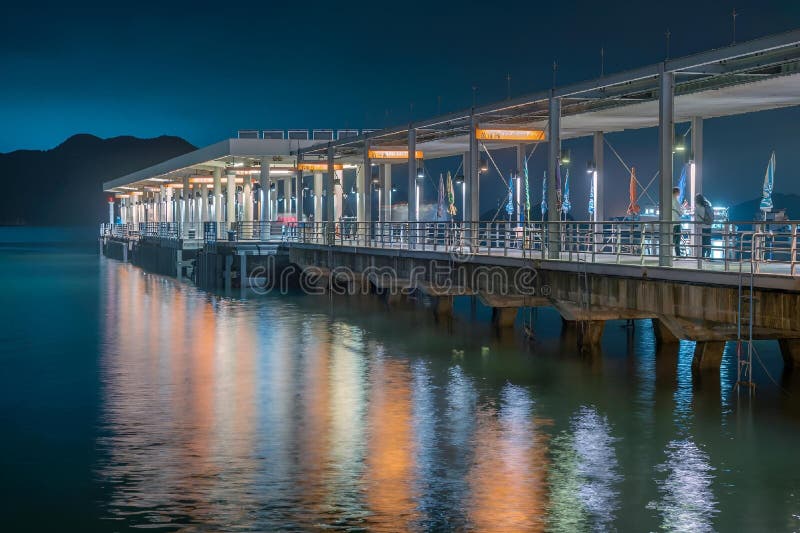 A Dock at Night Next To the Ocean and Mountains with Lights Editorial ...