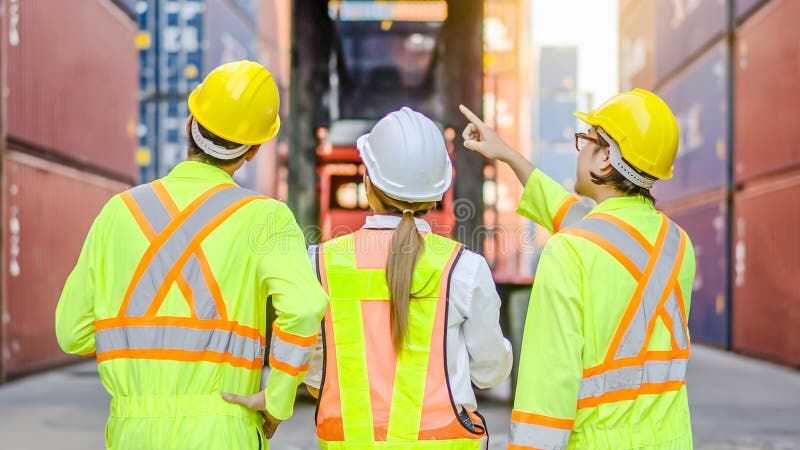 Dock Workers in Safety Gear Stand in Front of Massive Containers Stock ...