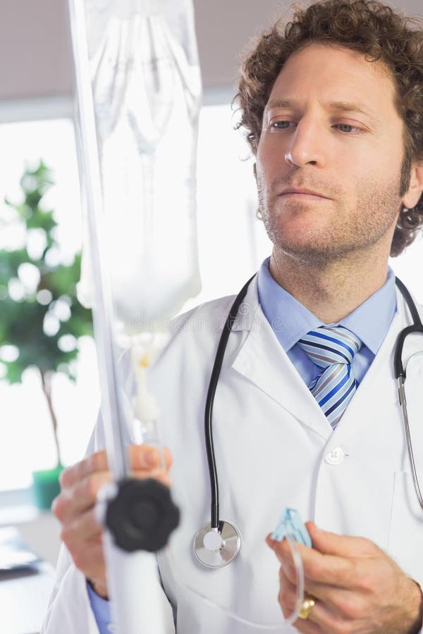 Doctor adjusting IV drip stock image. Image of expert - 37816499