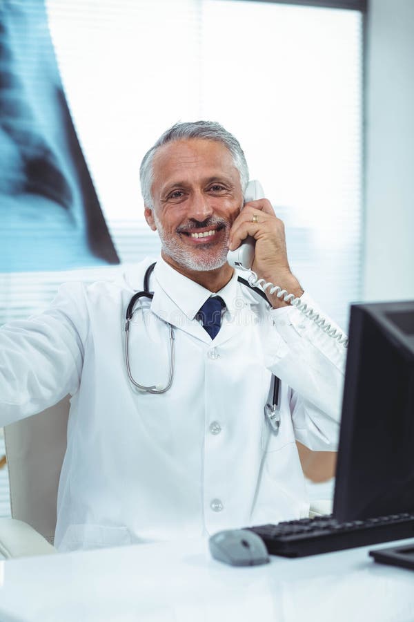 Doctor Checking a X-ray Report while Talking on Phone Stock Photo ...