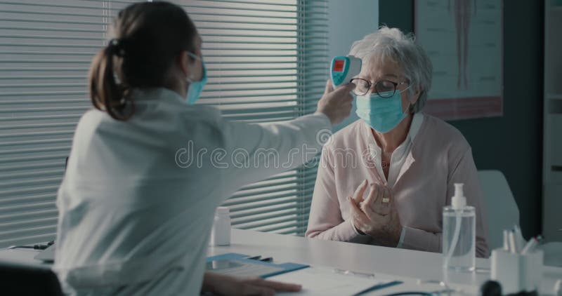 Doctor Checking a Patient`s Body Temperature Using a Infrared ...