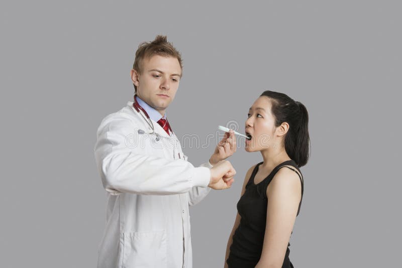 Doctor Checking Temperature of Female Patient Stock Photo - Image of ...