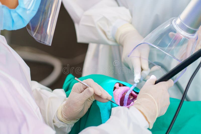The Doctor Cleaning the Teeth Patient with Ultrasonic Tool Stock Photo ...