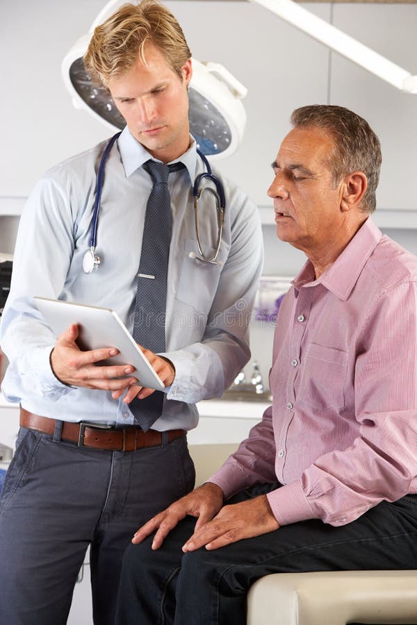 Doctor Discussing Records with Patient Using Digital Tablet Stock Image ...