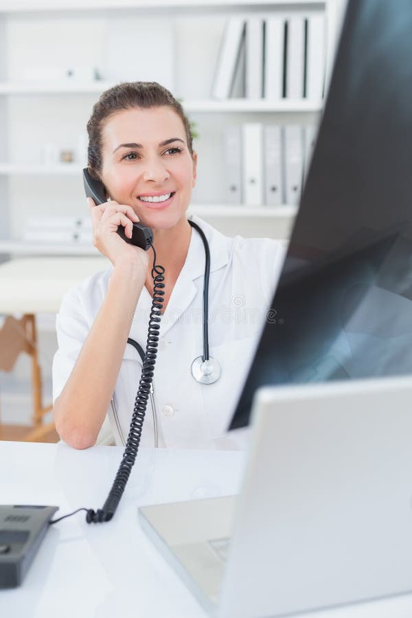 Doctor Doing Phone Call while she Using Computer Stock Photo - Image of ...