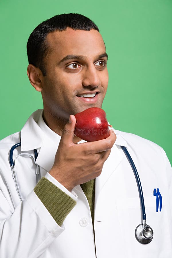Doctor eating an apple stock photo. Image of business - 62561494