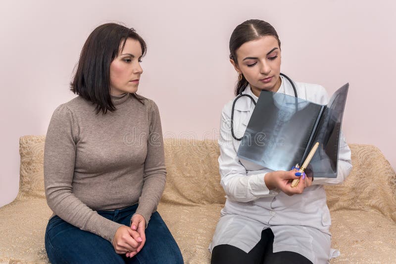Doctor Explaining Health Problems To Young Woman on X-ray Stock Image ...