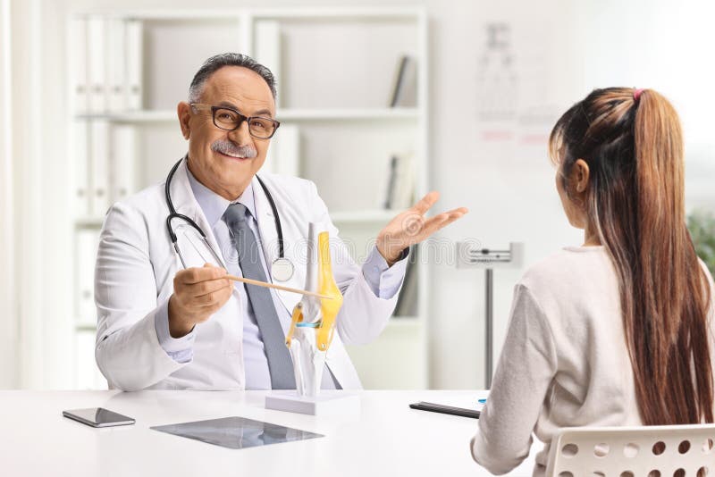 Doctor Explaining a Knee Bone Model To a Female Patient Stock Photo ...