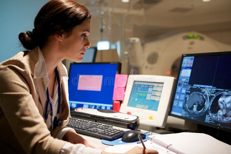 Doctor in Front of Computers Looking at X-rays in a Hospital Under the ...