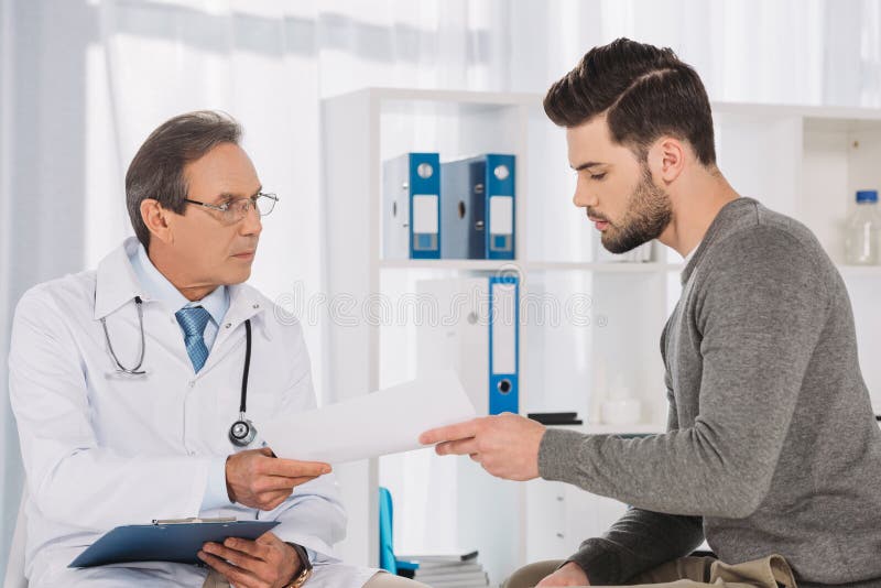 Doctor giving documents to stock image. Image of handsome - 119792299