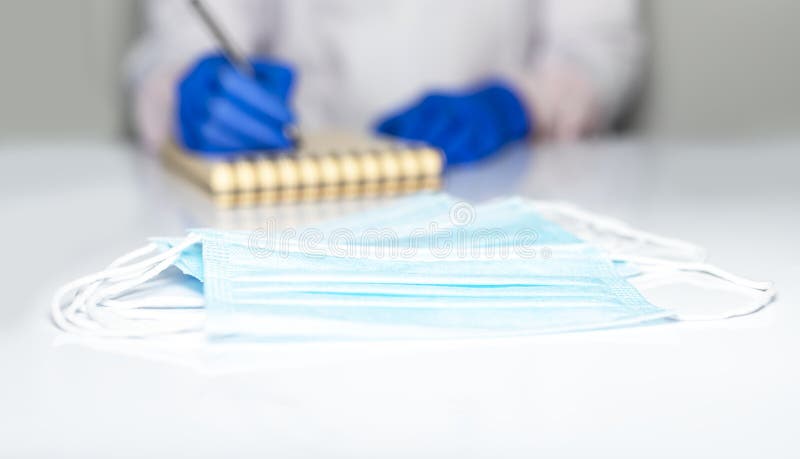 Doctor Hands in Gloves Make Notes. Medical Table with Masks Stock Image ...