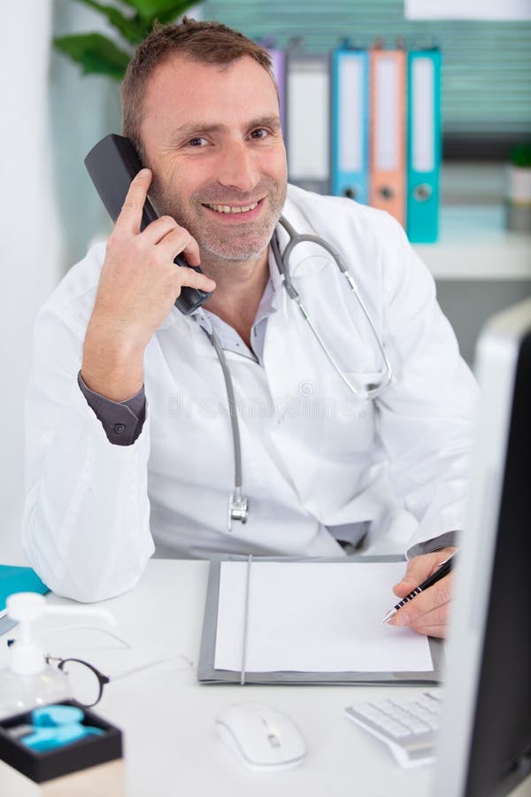Doctor at Desk Talking on Telephone Stock Image - Image of desk, intern ...