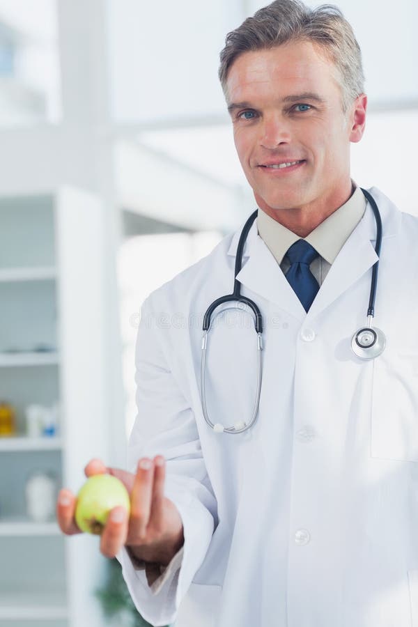 Doctor holding an apple stock photo. Image of holding - 31800614