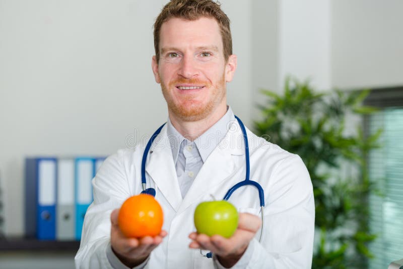Doctor Holding Apple and Orange Stock Photo - Image of orange, concept ...