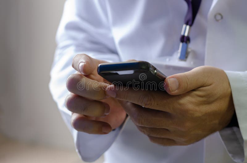 The Doctor is Holding the Phone in His Hand and Checking His Messages ...