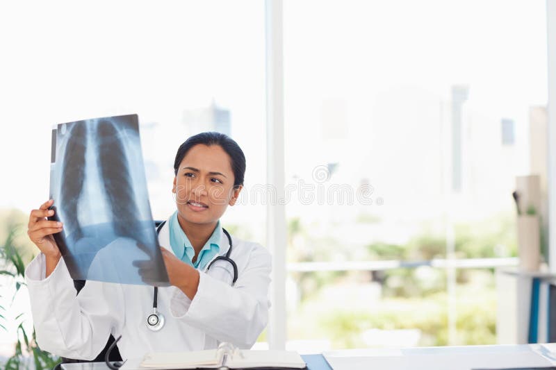 Indian Woman Doctor Examining Chest X-ray Film in White Lab Coat at Clinic Desk with Stethoscope ...
