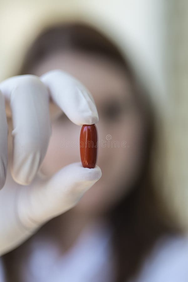 Doctor holding red pill stock image. Image of container - 58641631
