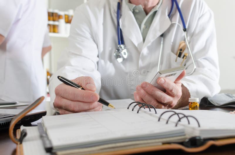Doctor Holding a Smartphone and Taking Notes Stock Image - Image of ...