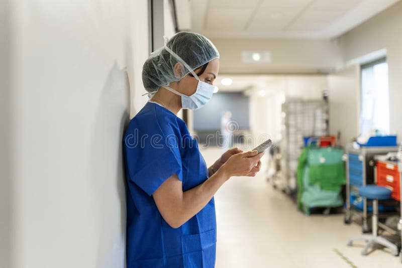 Doctor Leaning Against the Wall Using the Mobile Phone in a Hospital ...
