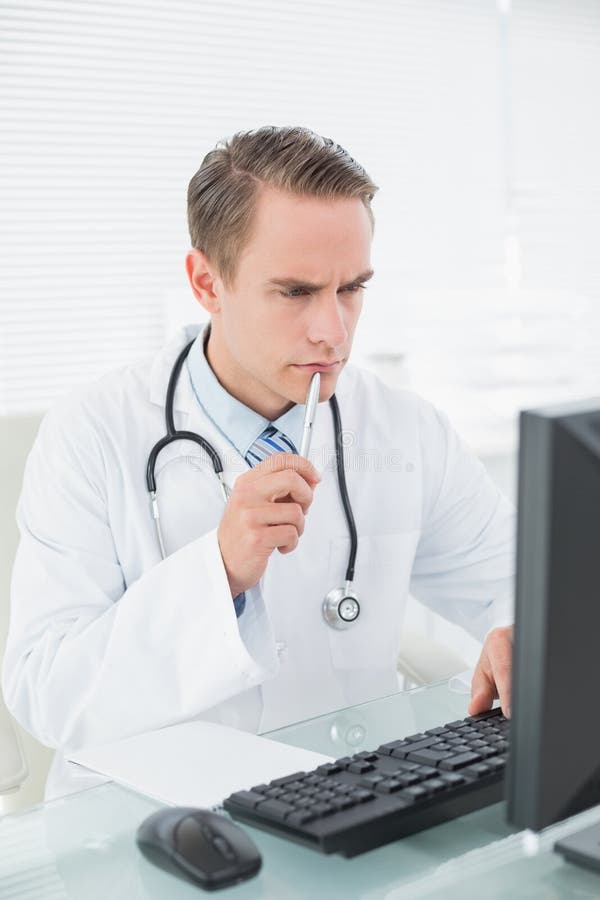 Doctor Looking at Computer in Medical Office Stock Photo - Image of ...