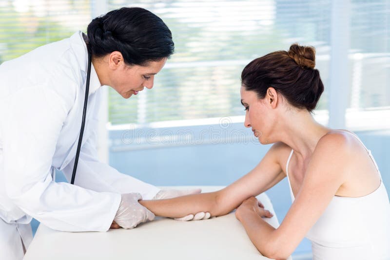 Doctor Looking at Her Patients Arm Stock Image - Image of service ...