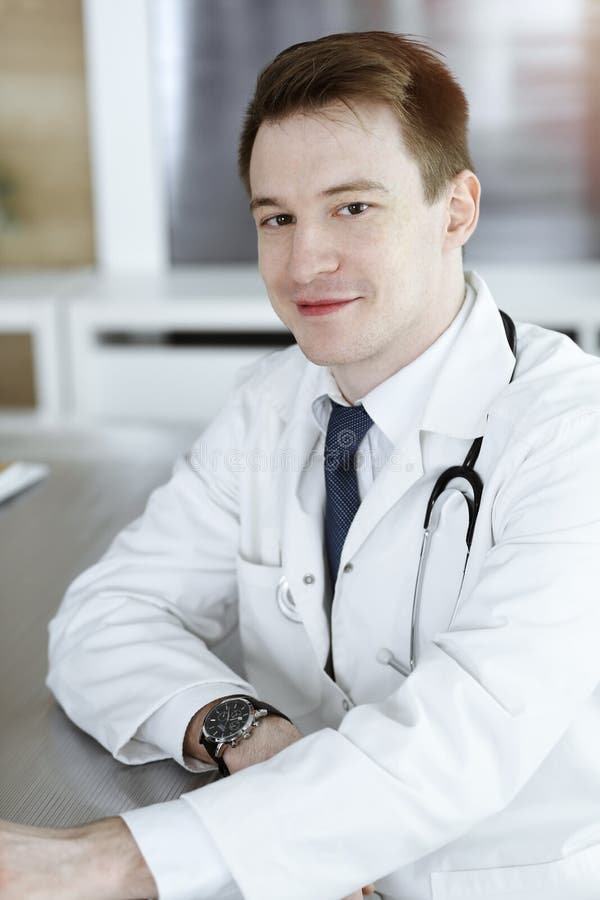 Doctor Man Sitting Behind a Computer at Workplace in Sunny Clinic Stock ...