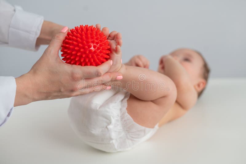 A Doctor Massages a Baby& X27;s Foot Using a Spiked Ball. Stock Image ...