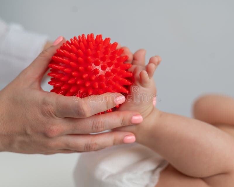 A Doctor Massages a Baby& X27;s Foot Using a Spiked Ball. Stock Photo ...