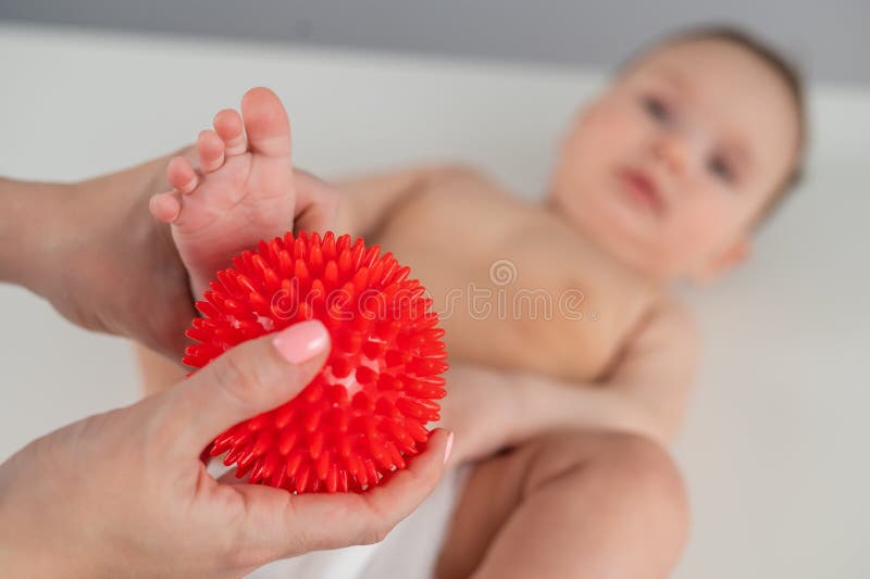 A Doctor Massages a Baby& X27;s Foot Using a Spiked Ball. Stock Photo ...