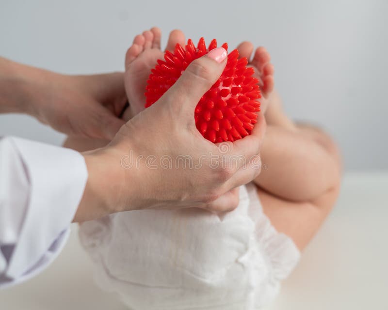 A Doctor Massages a Baby& X27;s Foot Using a Spiked Ball. Stock Image ...