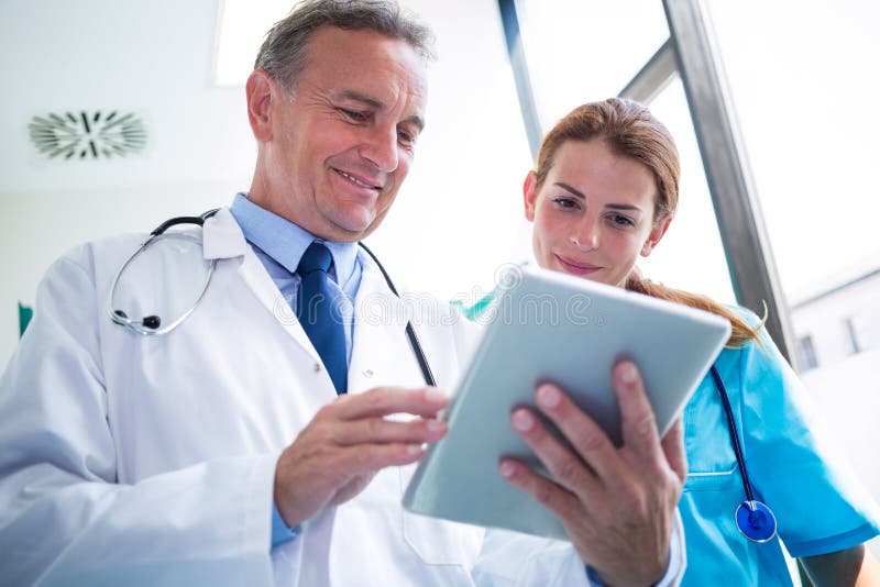 Female Asian Doctor Talking with African American Doctor with Tablet ...